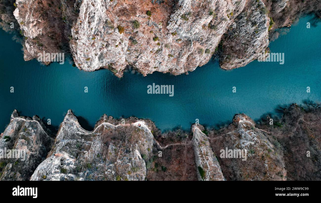 An aerial view of water flowing between two rocky formations with trees ...