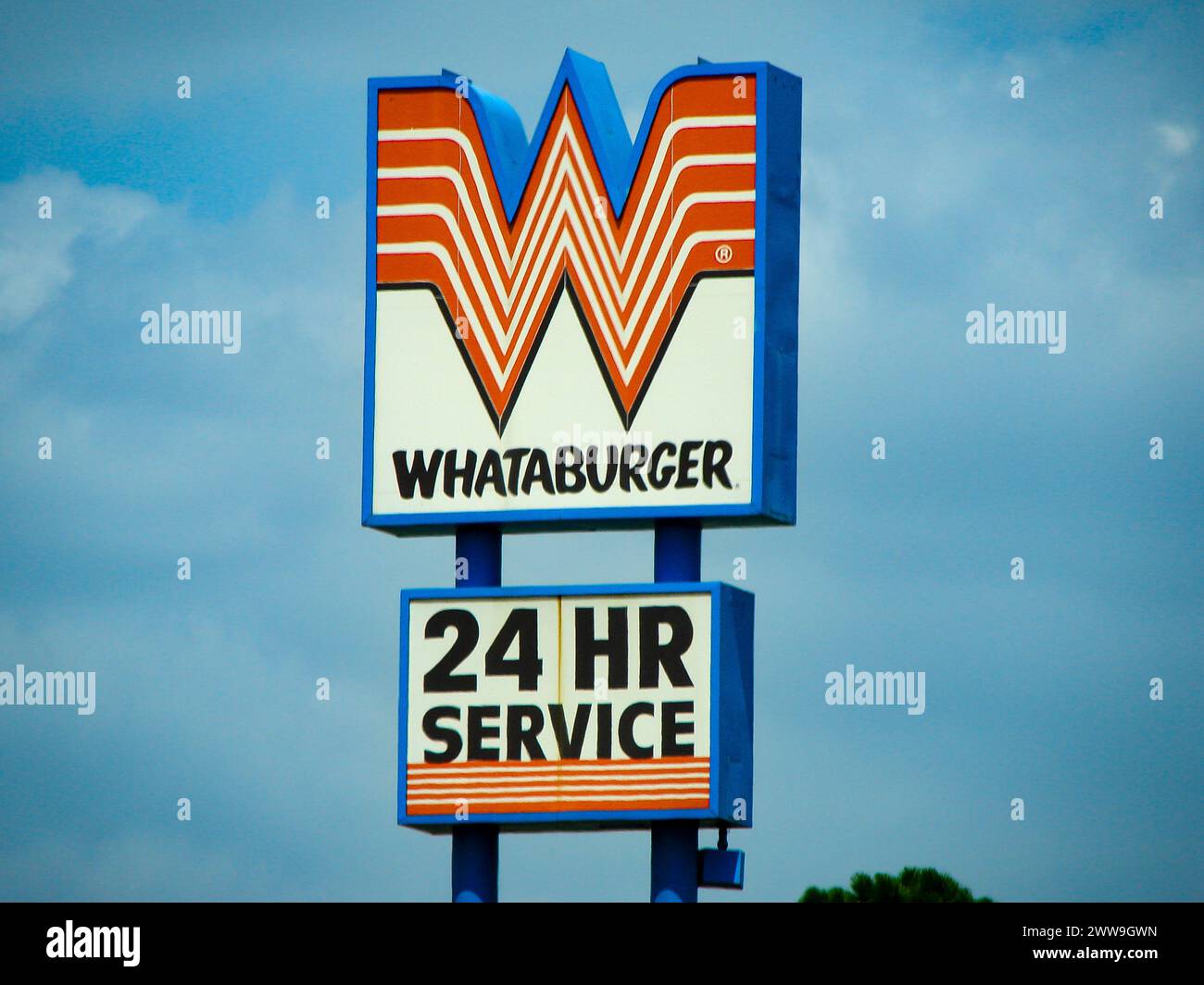 Whataburger Restaurant with 24 hr service sign with a blue cloudy sky ...