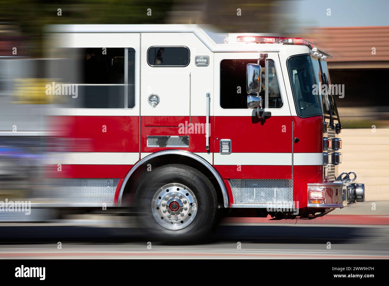 Motion panned view of a fire engine responding to the scene of an ...
