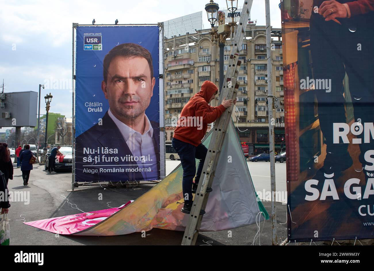 Bucharest, Romania. 22th Mar, 2024: A man installs an advertising ...