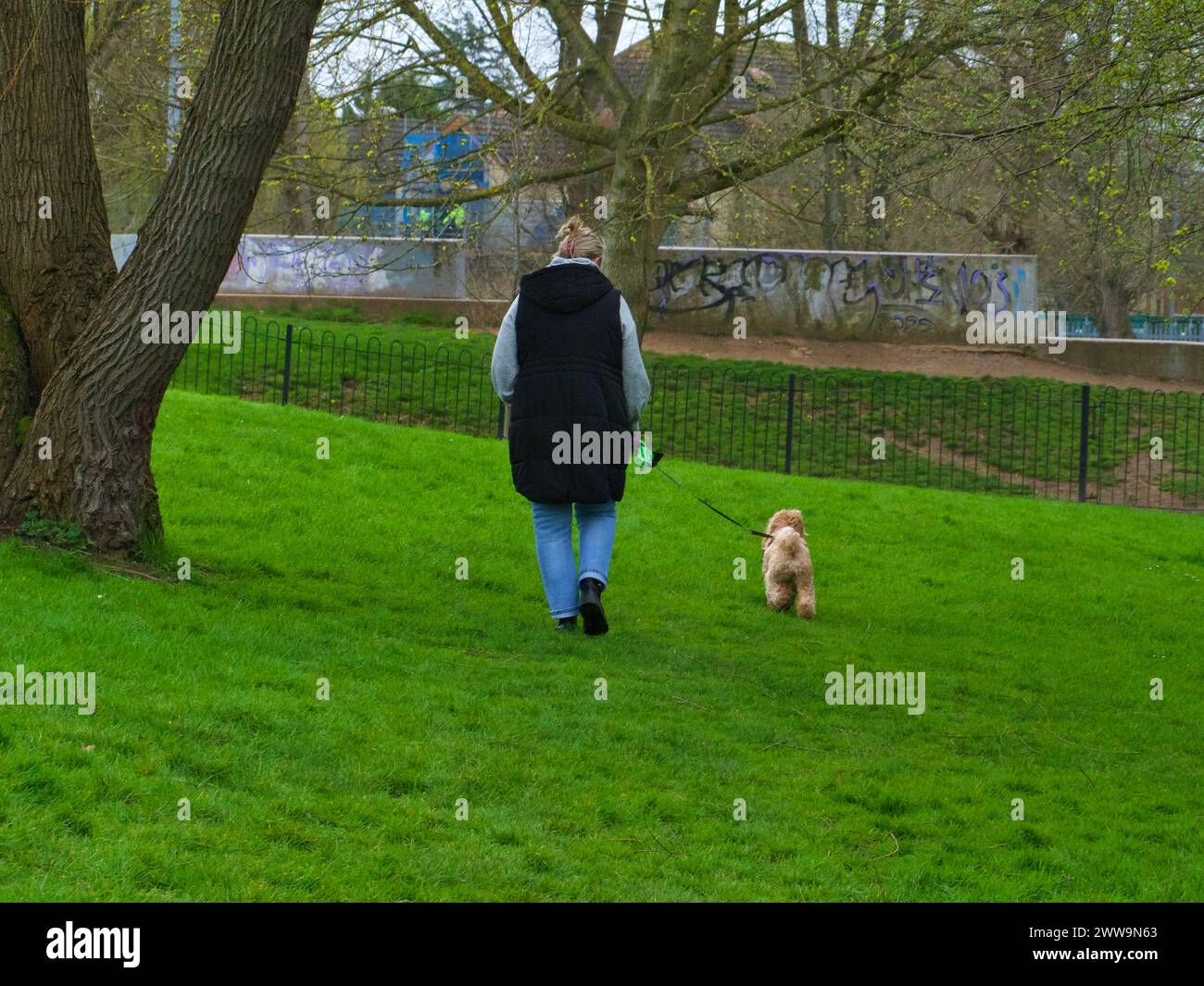 Woman in coat walking park hi-res stock photography and images - Alamy