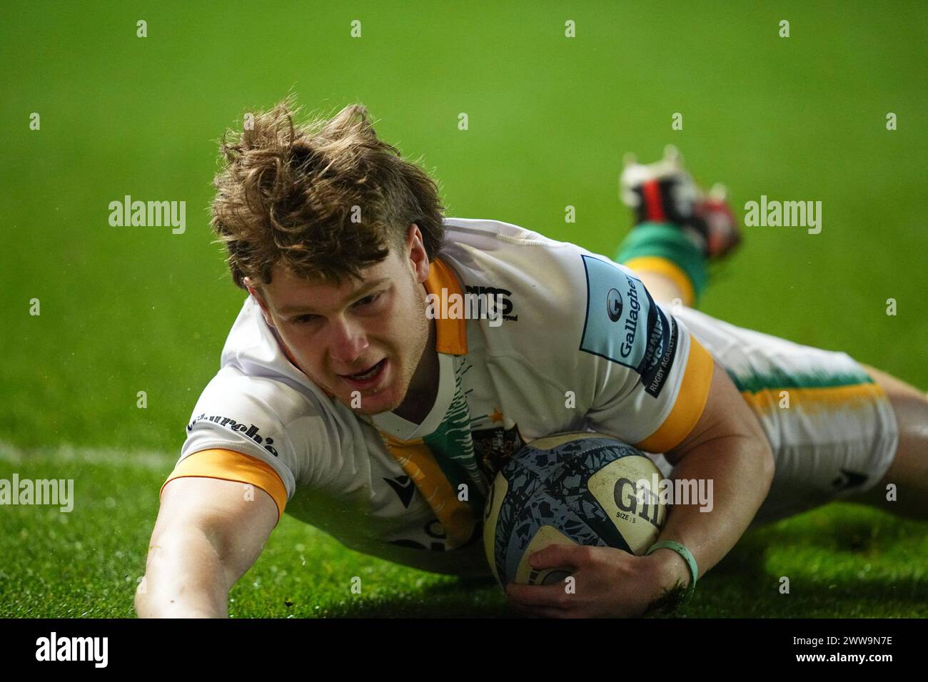 Jake Garside of Northampton Saints slides in to score a try during the ...