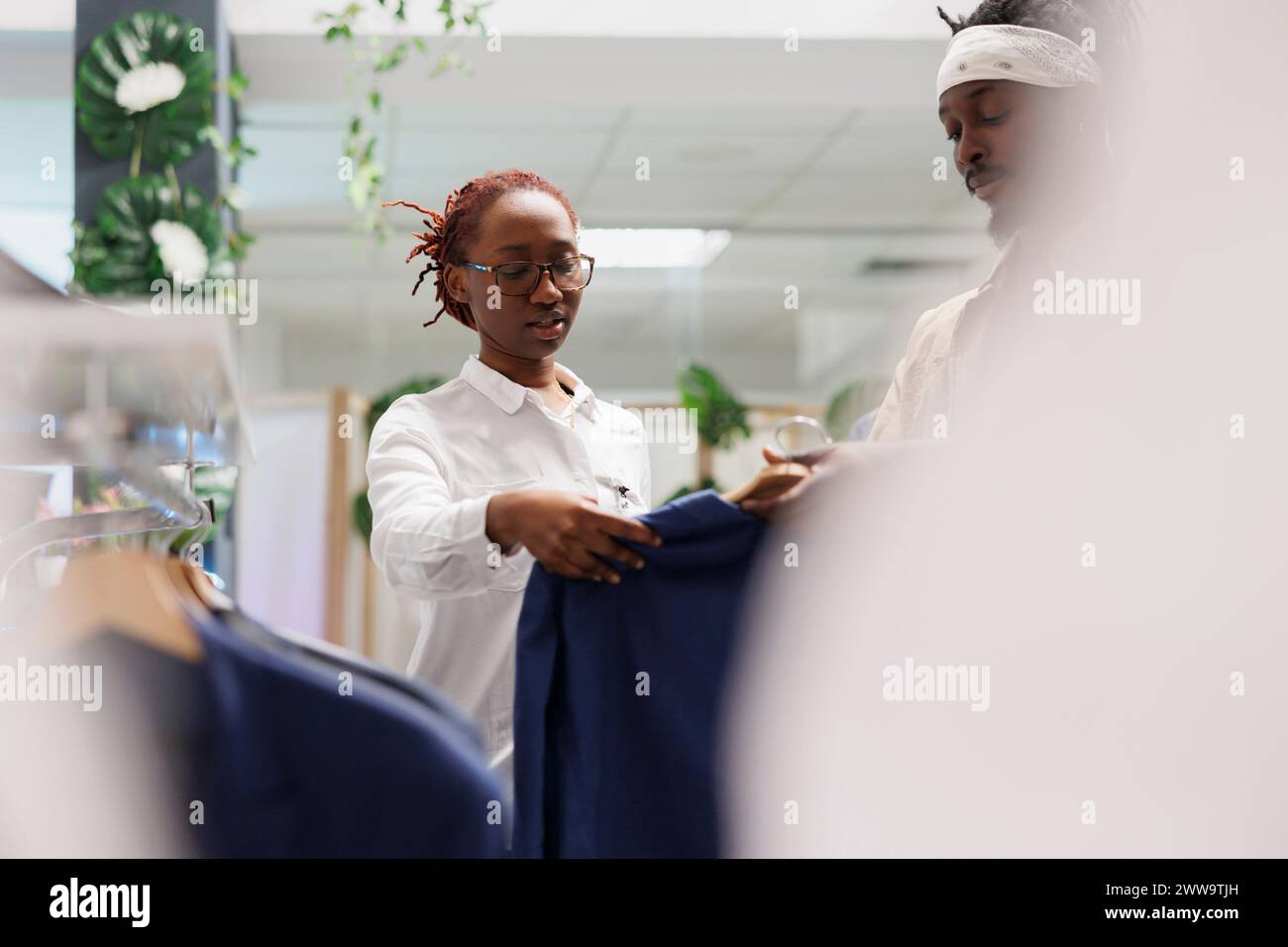 Customer asking clothing store assistant about jacket size in fashion ...