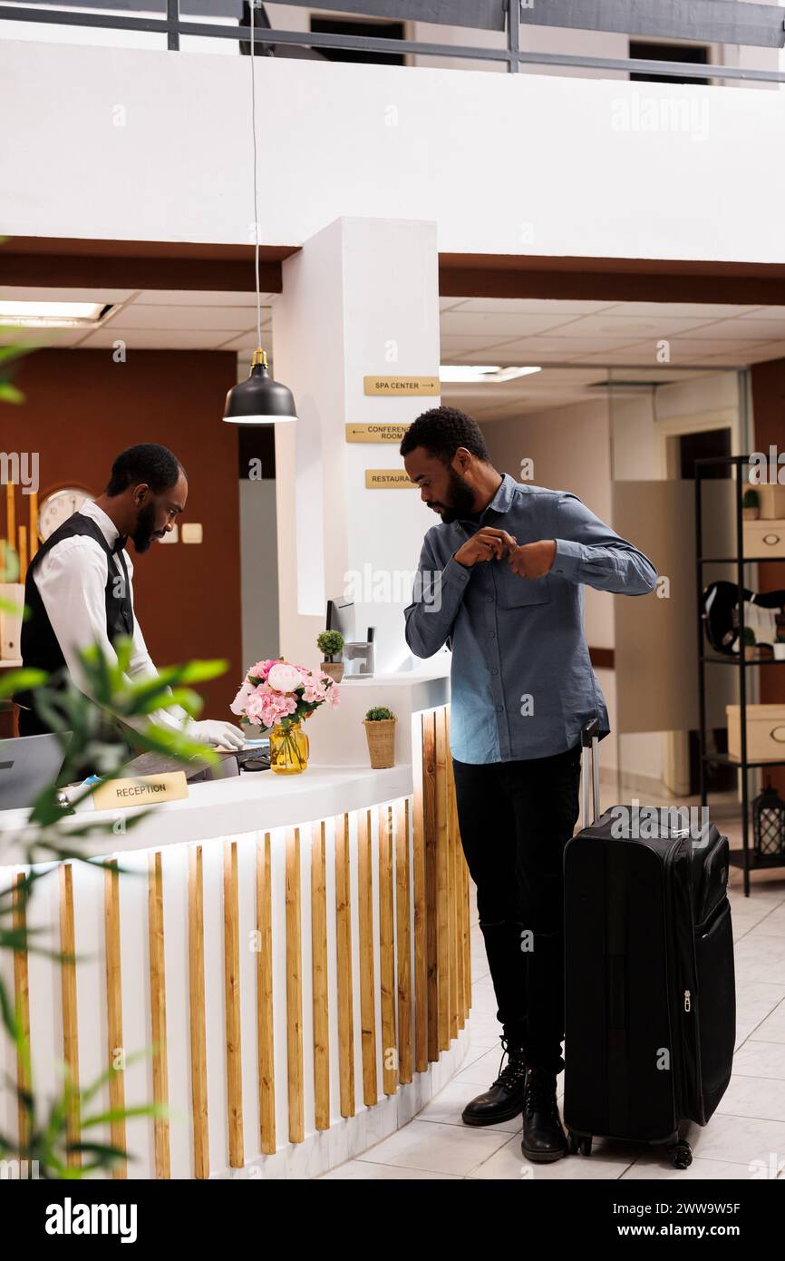 Young African American man tourist arriving to hotel, standing alone ...
