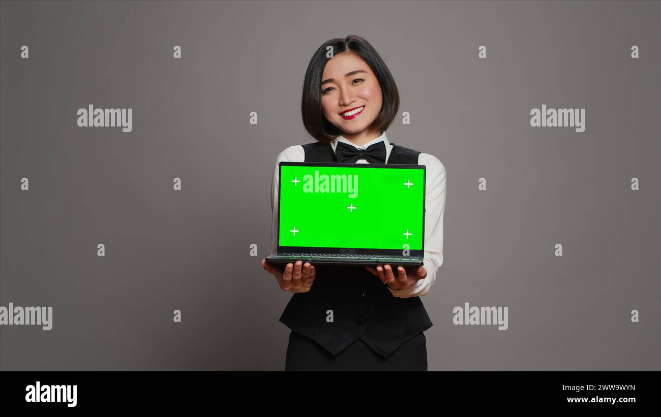 Receptionist showing greenscreen display on personal laptop, presenting ...