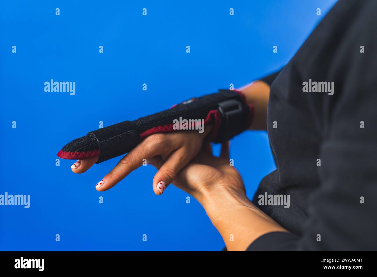 woman showing a two-sided splint on her middle finger, injured finger ...
