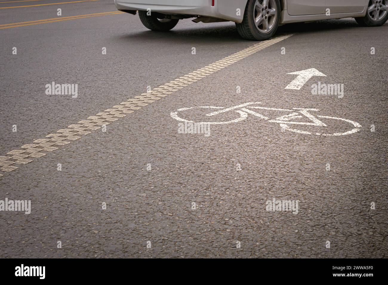 A vehicle crossing a bicycle lane marked with painted bike and ...