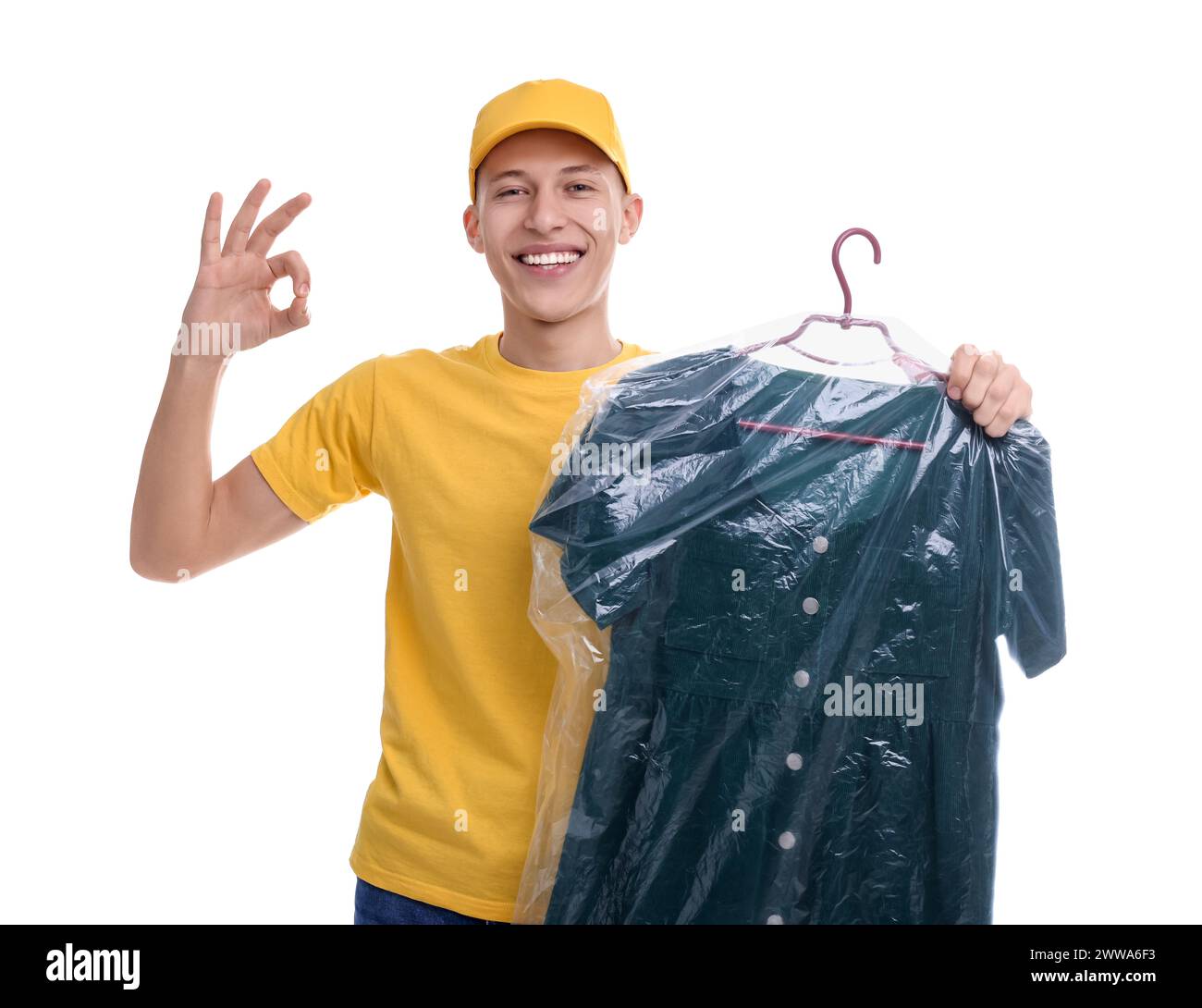 Dry-cleaning delivery. Happy courier holding dress in plastic bag and ...