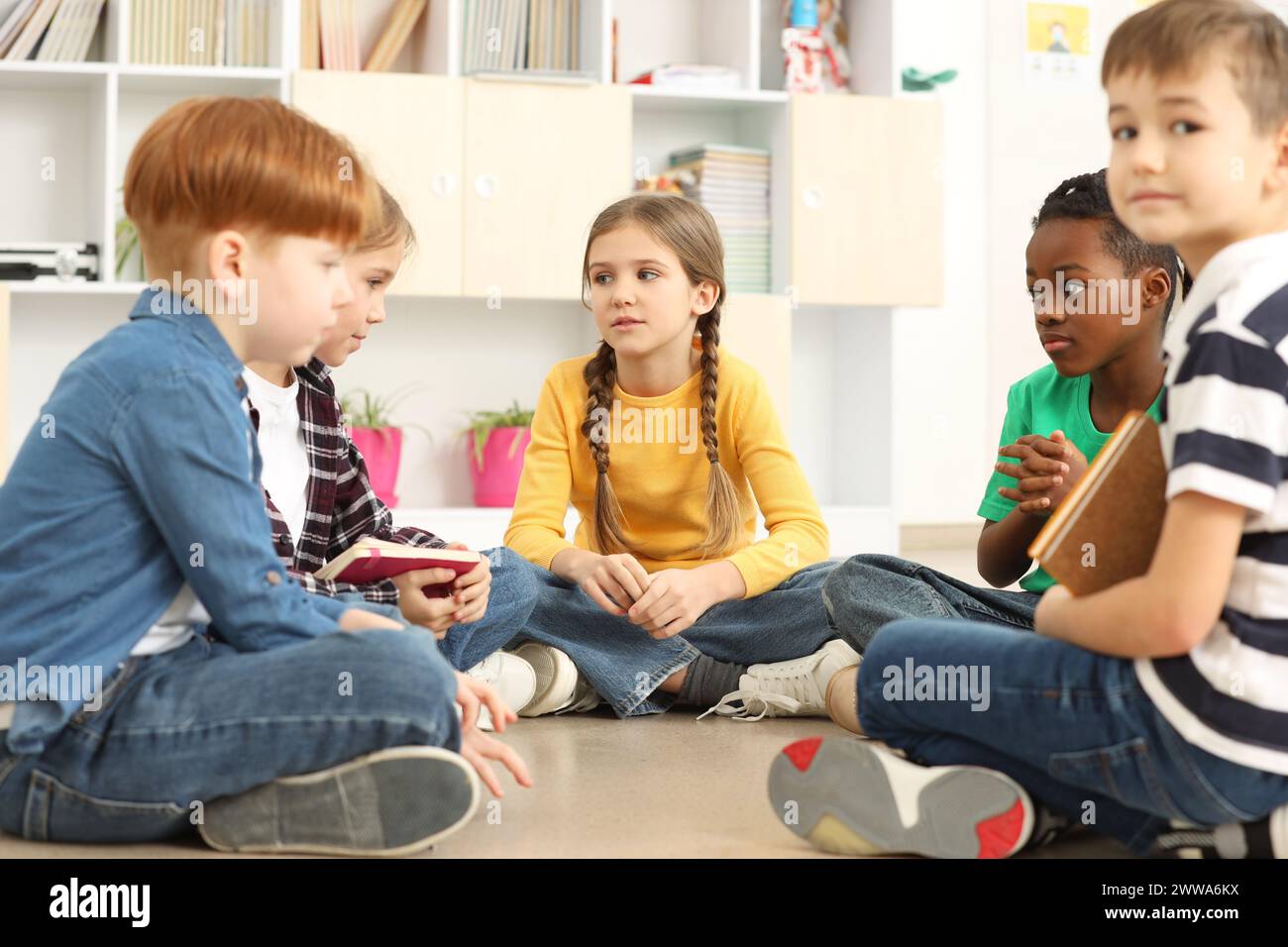 Cute children discussing in classroom at school Stock Photo - Alamy