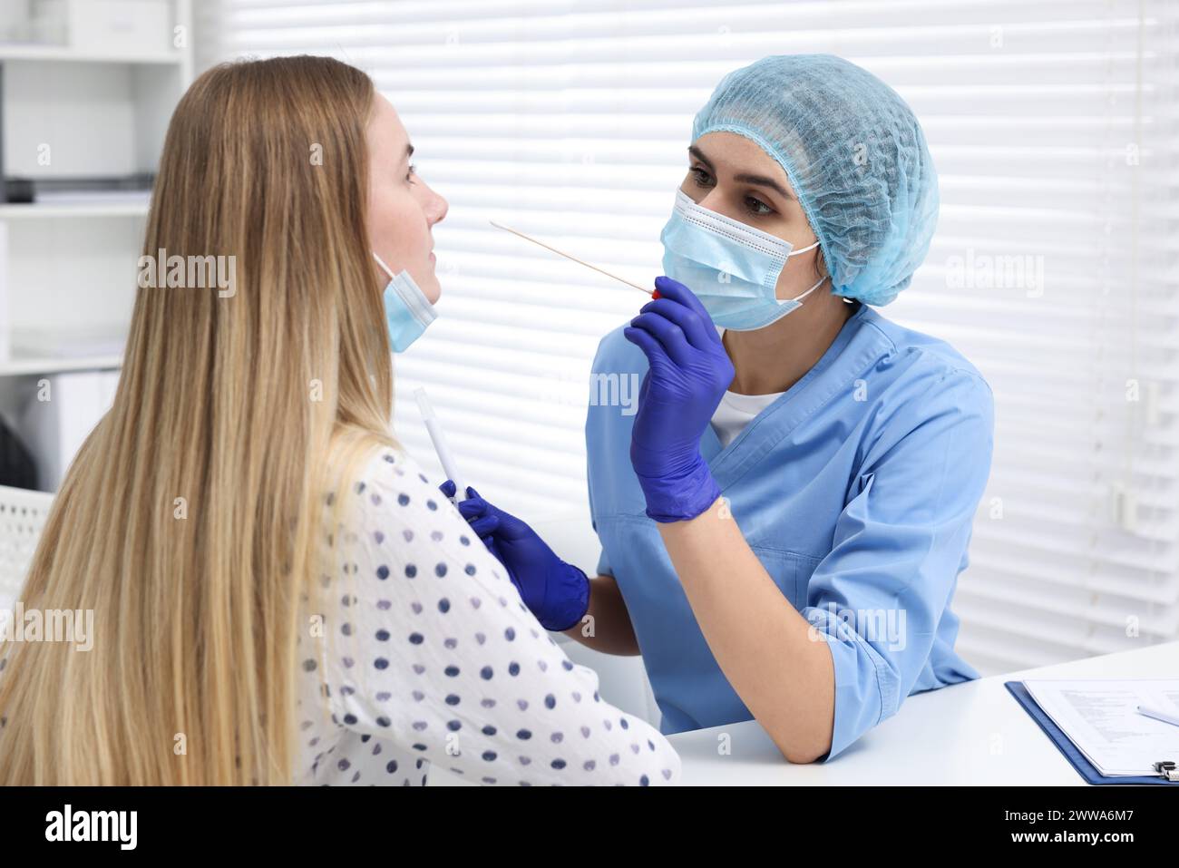 Laboratory testing. Doctor taking sample from patient's nose with ...