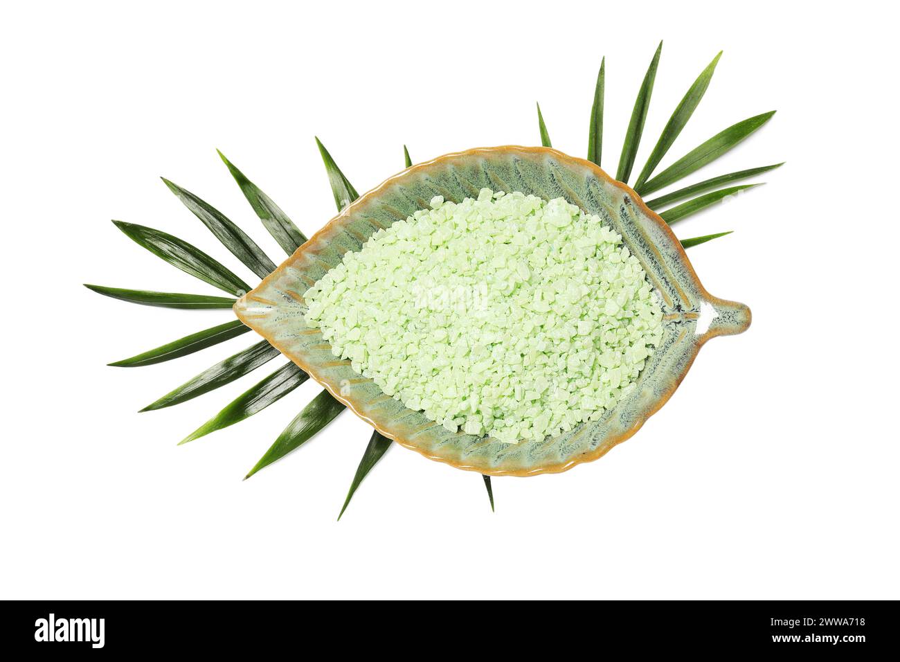 Green sea salt in bowl and palm leaves isolated on white, top view ...