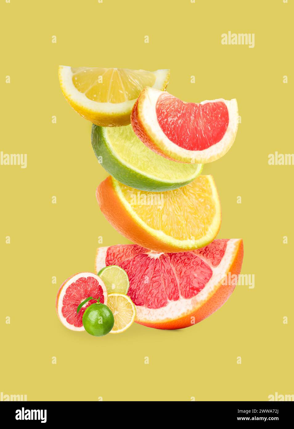 Stack of different citrus fruits on pale yellow background Stock Photo ...