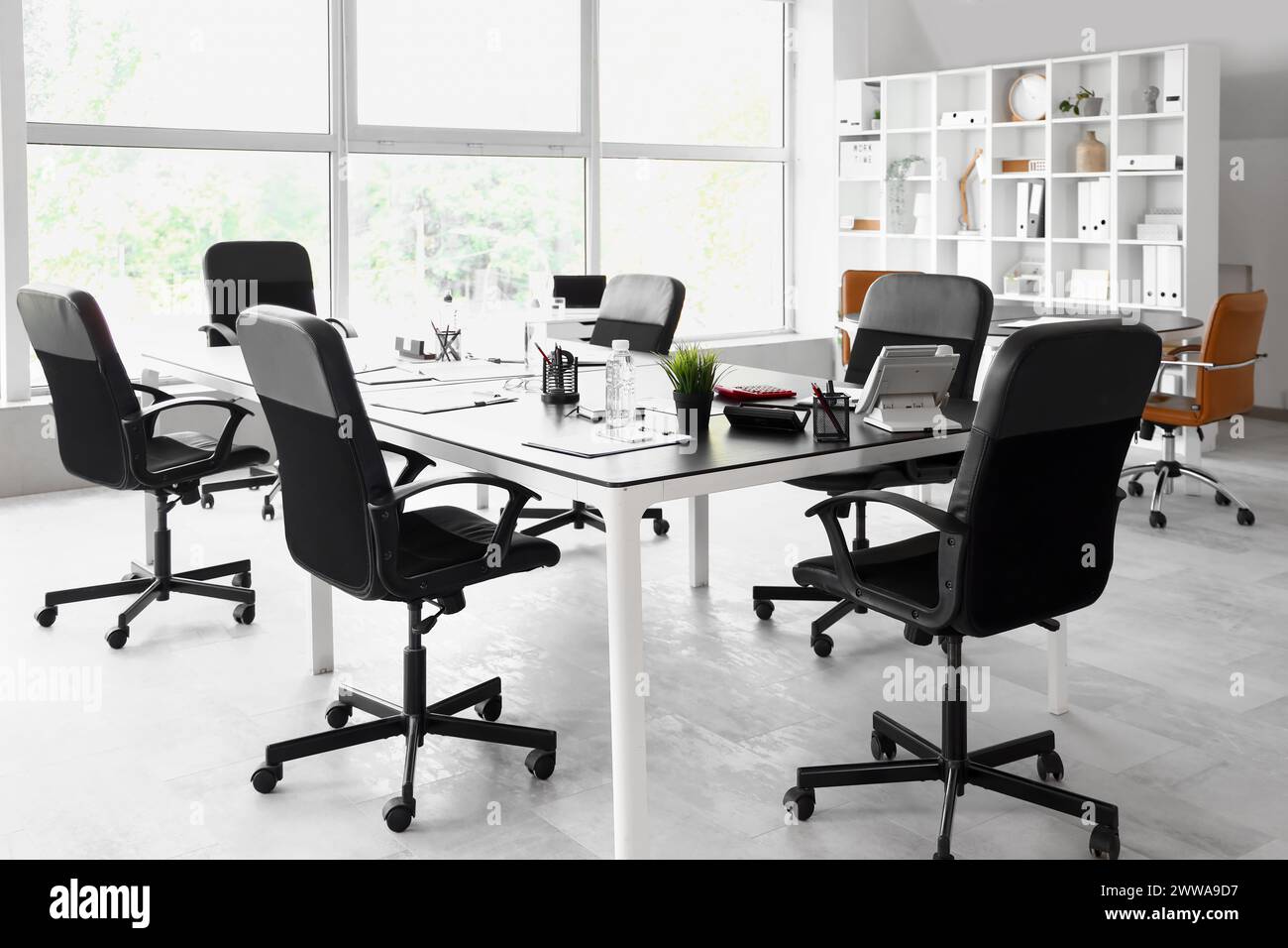 Interior of conference room with desks and shelf unit Stock Photo - Alamy