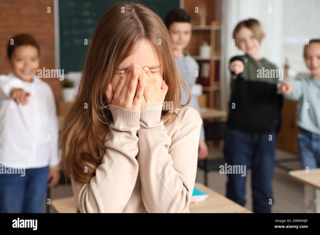 Bullied little girl crying in classroom, closeup Stock Photo - Alamy