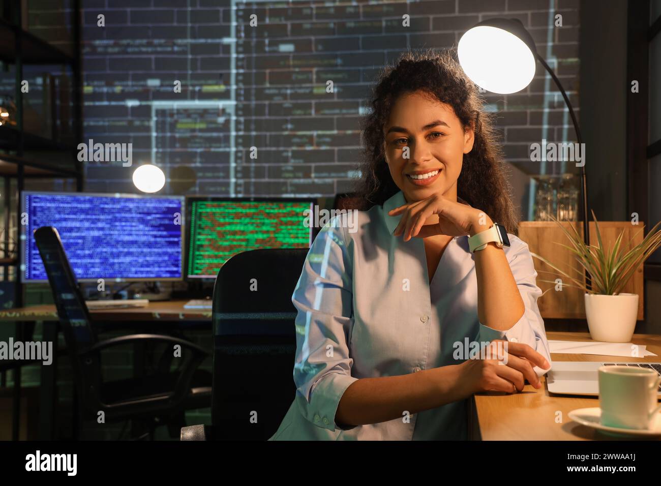 Female African-American programmer sitting in office at night Stock ...