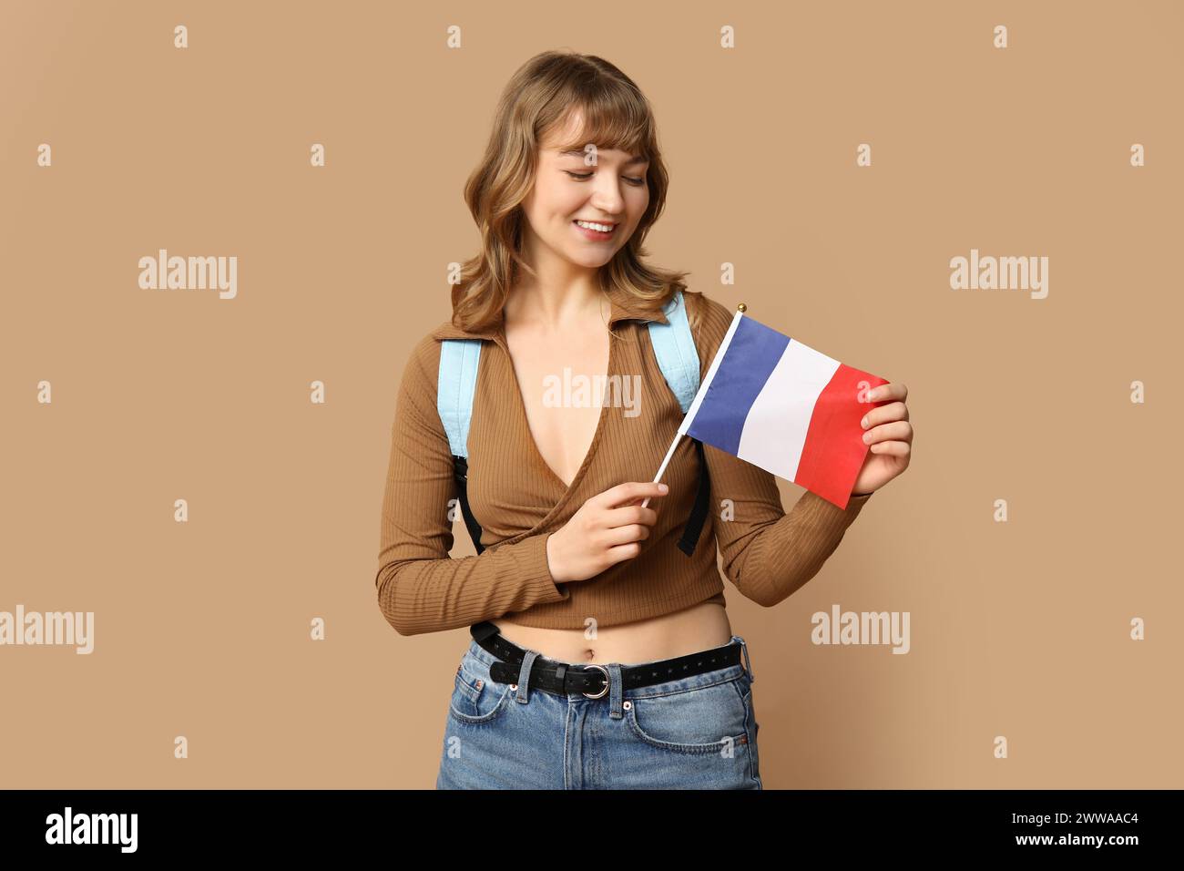 Female student with French flag on beige background Stock Photo - Alamy