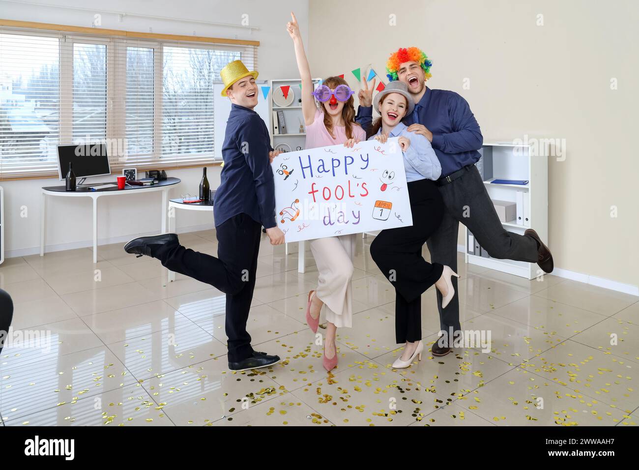 Business people with poster celebrating April Fools' Day at office ...