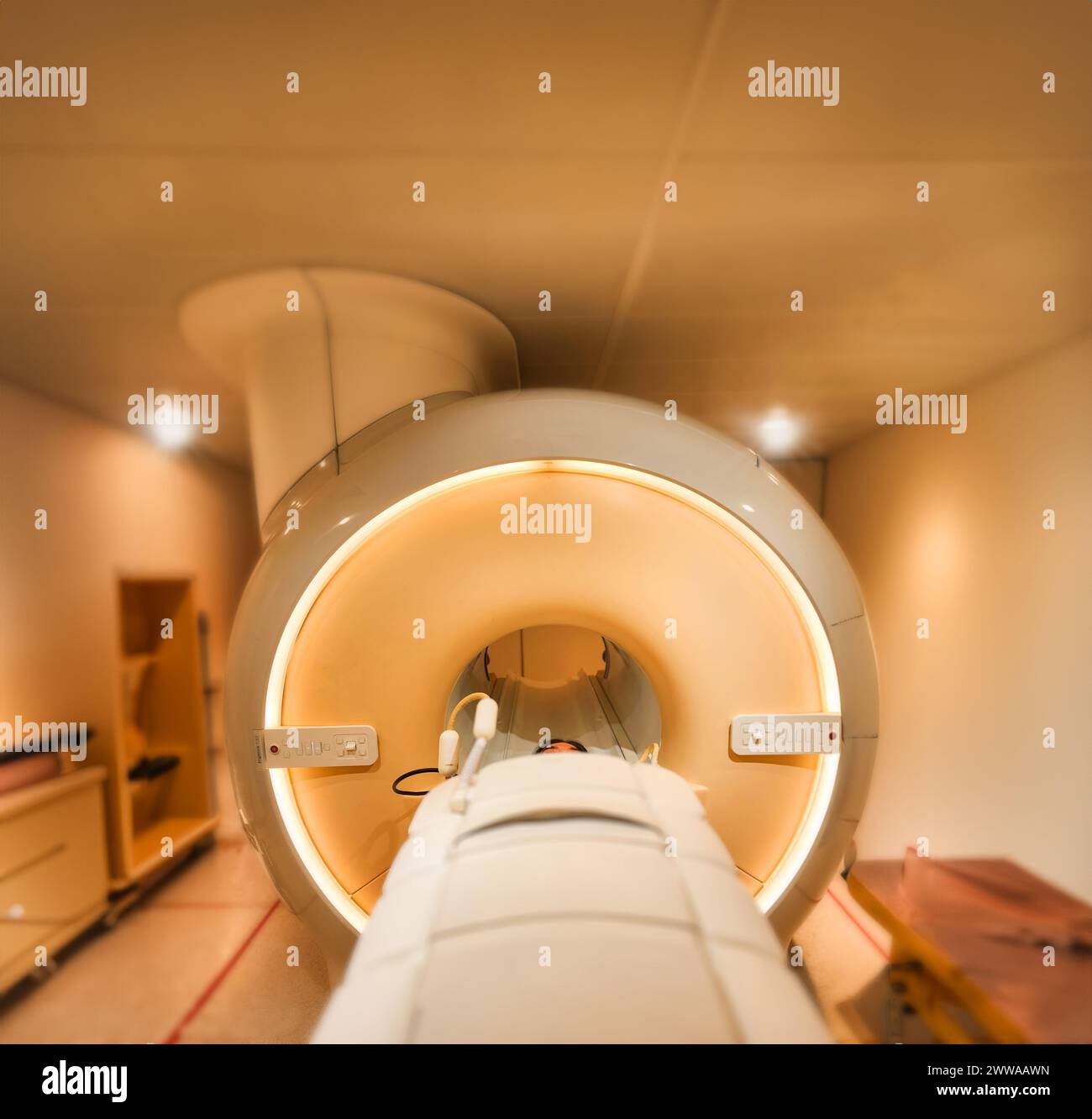 A patient lies down comfortably on the MRI scanner, undergoing a ...