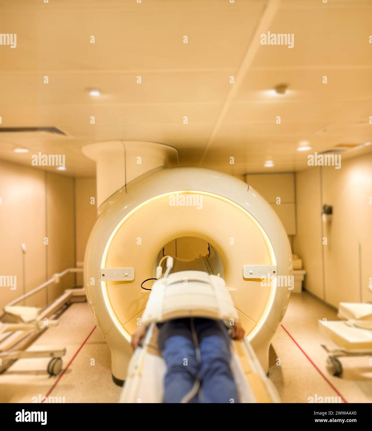 A patient lies down comfortably on the MRI scanner, undergoing a ...