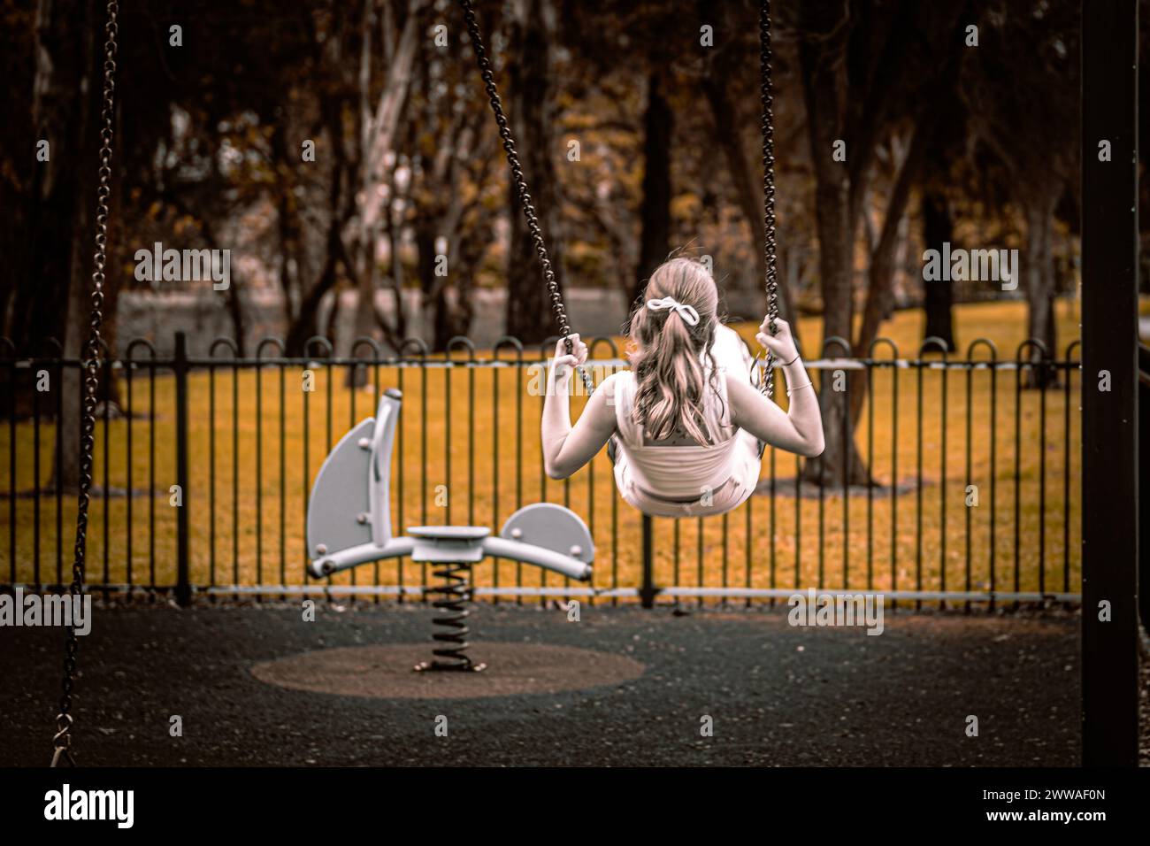 A child swings alone, captured in a poignant moment of childhood ...