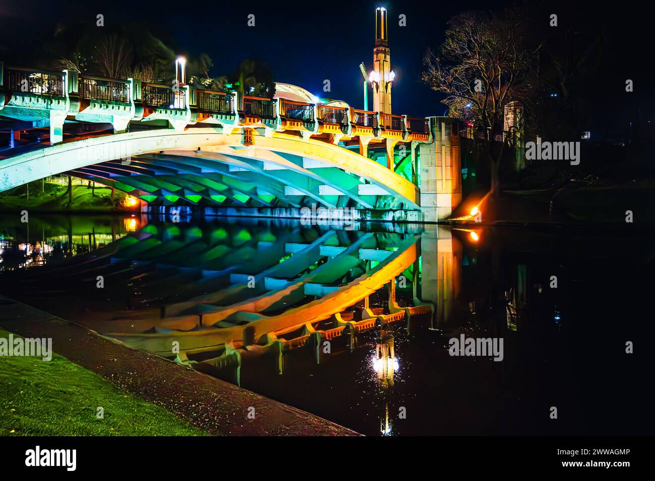 Night lights reflect on the water under a beautifully illuminated city ...