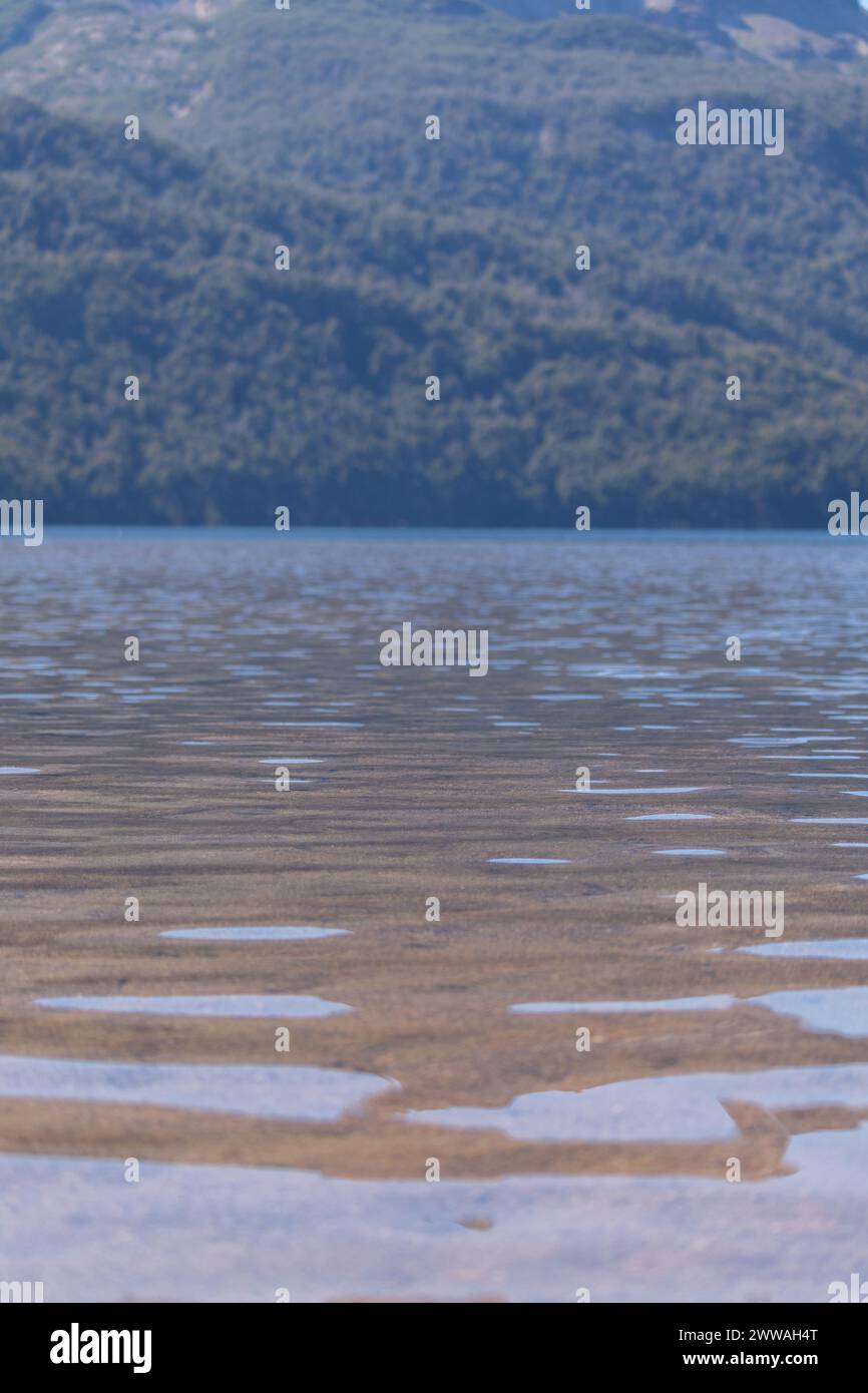 Vertical view, wavy brown lake water on the bottom, and distanced ...