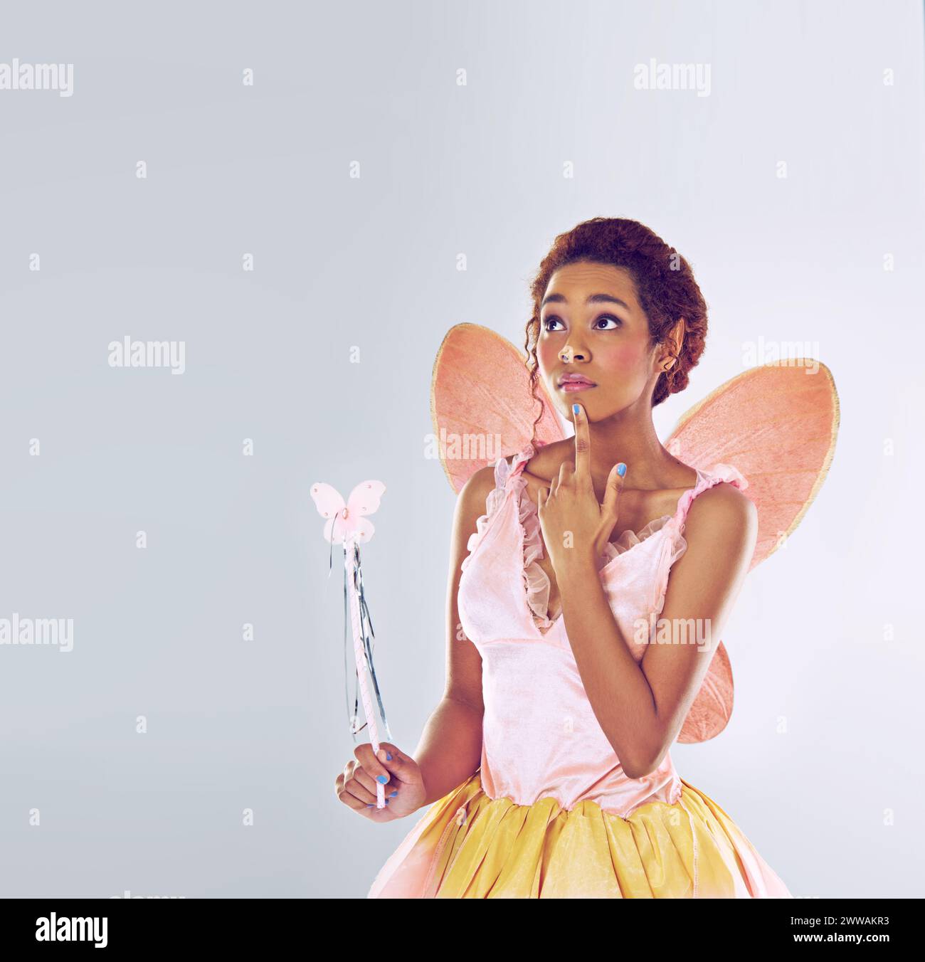 Woman, fairy and costume for fantasy in studio with wand, thinking and ...