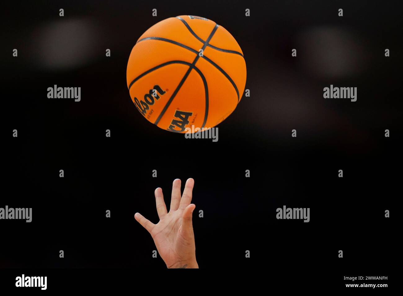 A player hand reaches for the loose ball during a first-round college ...