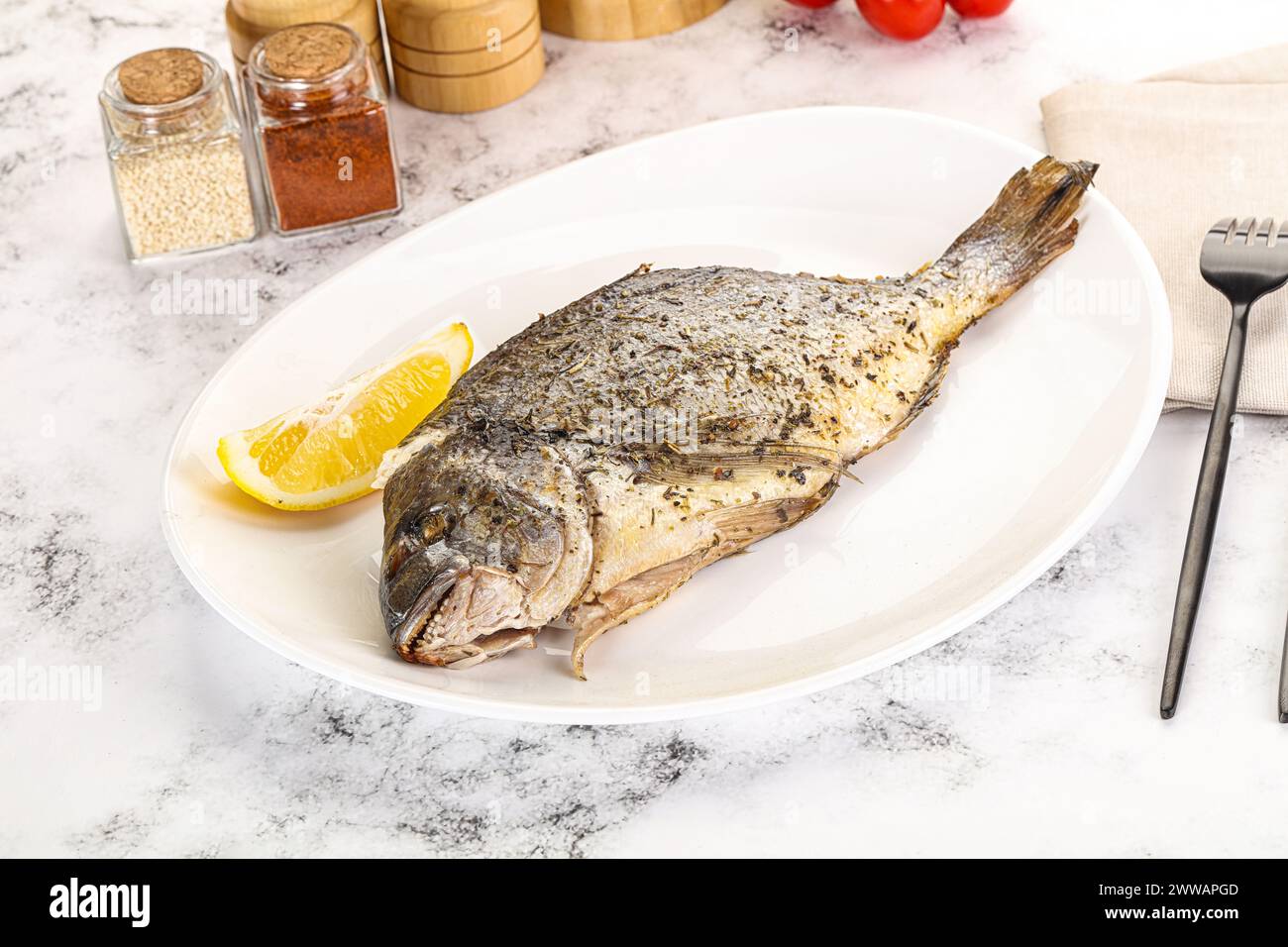 Baked Dorado fish served lemon slice Stock Photo - Alamy