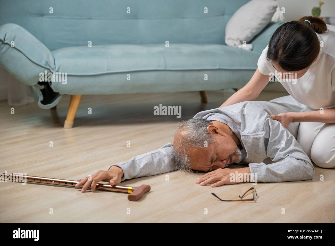 old man falling down lying on floor with walking stick and assistant ...