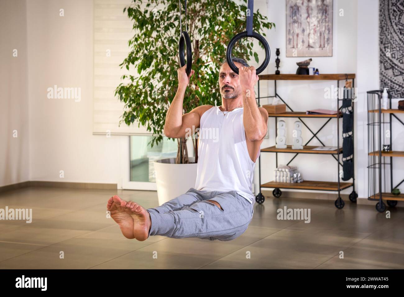 Full body of focused man in activewear practicing stretching exercises ...