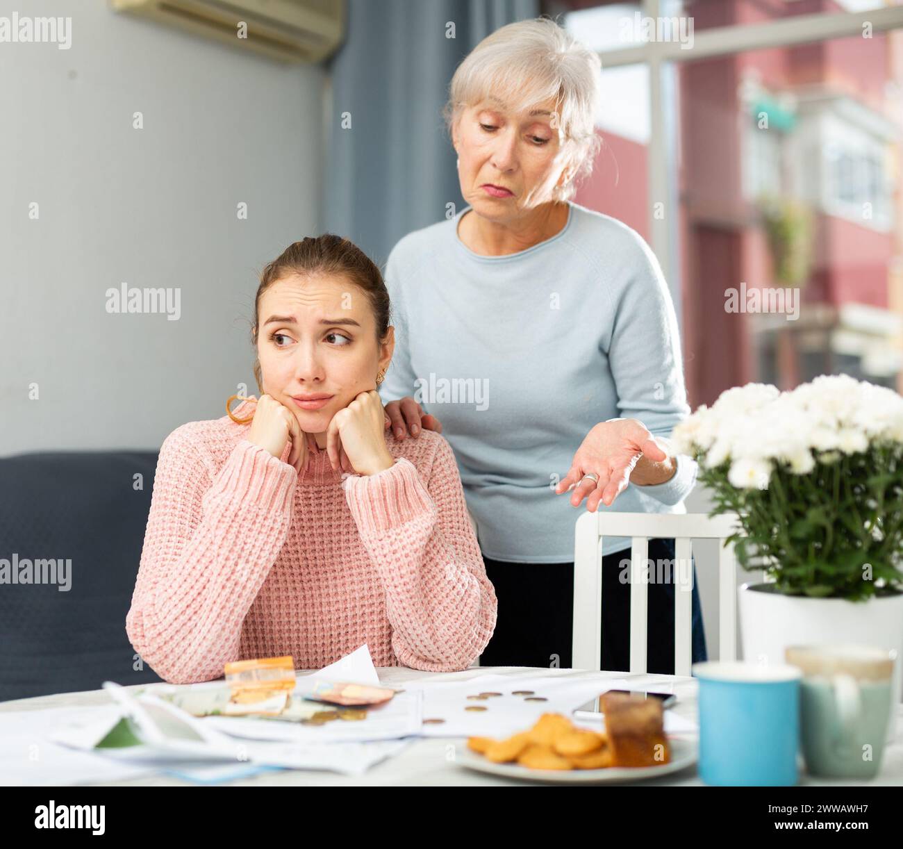 Sad young woman and mother counting money Stock Photo - Alamy