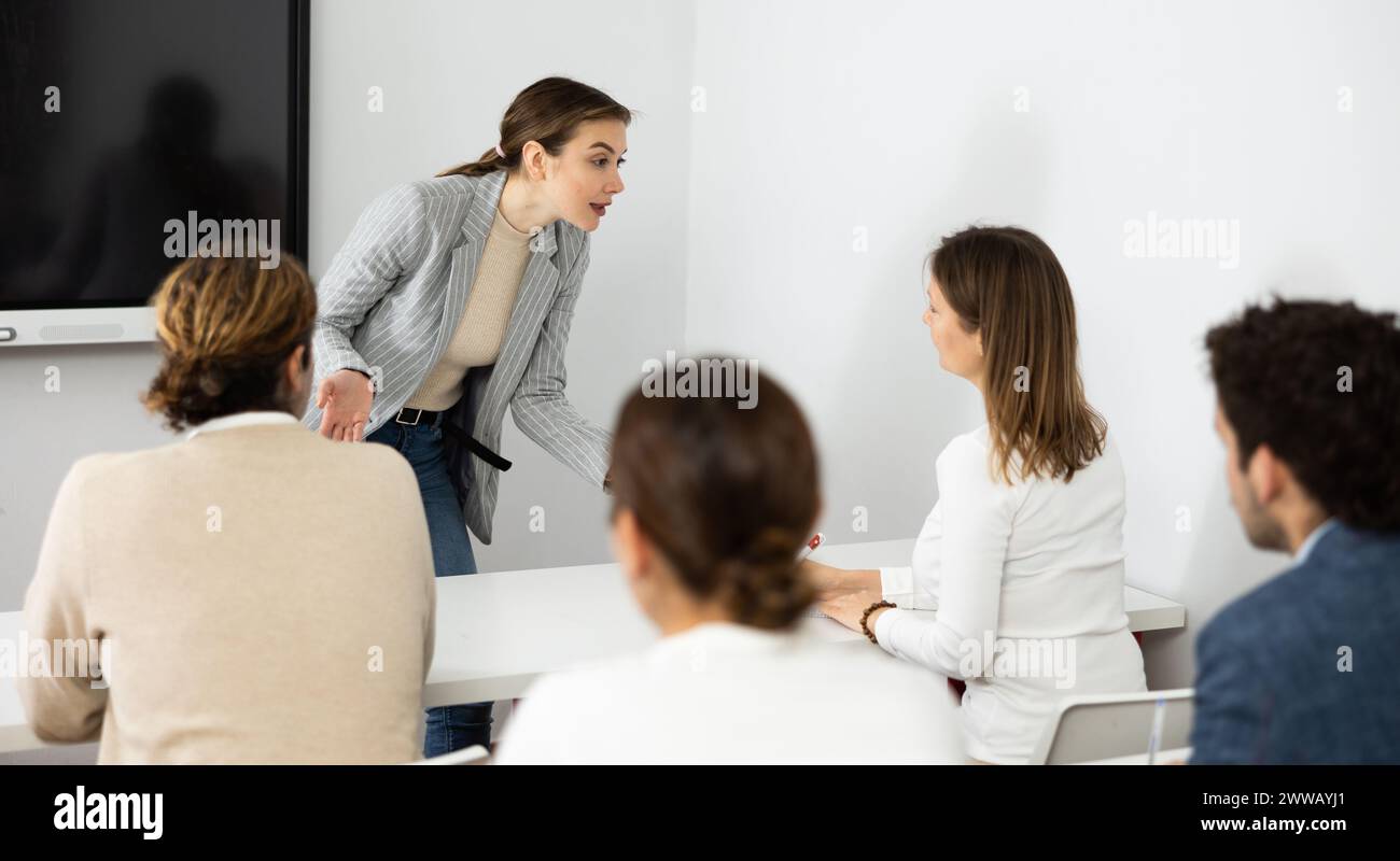 Young female teacher giving lecture to group of student Stock Photo - Alamy