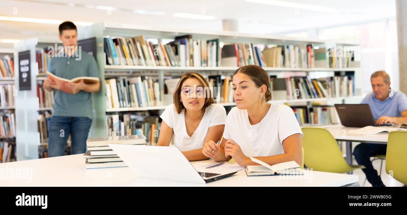 Student girls work together on project in the college library Stock ...