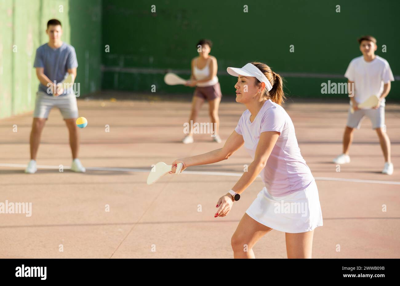 Portrait of sporty girl playing paleta fronton on outdoor court, ready ...