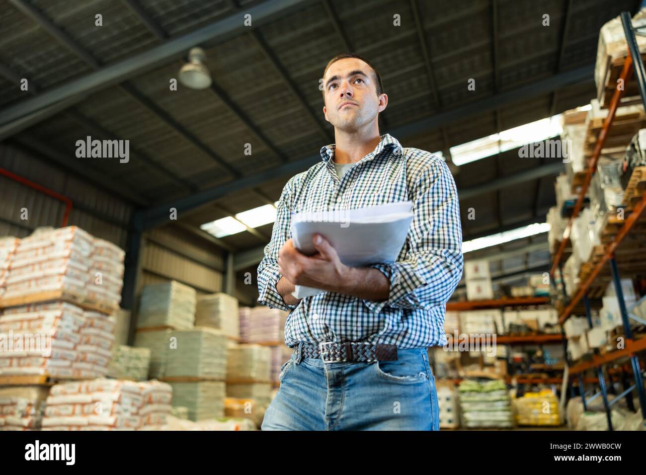Man inspecting warehouse to check quantity of goods on shelves Stock ...