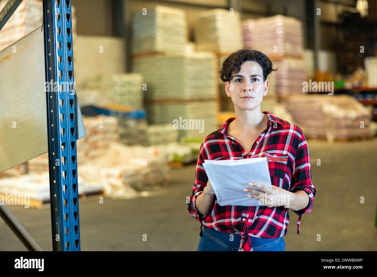Female storekeeper checks presence of goods in the building materials ...