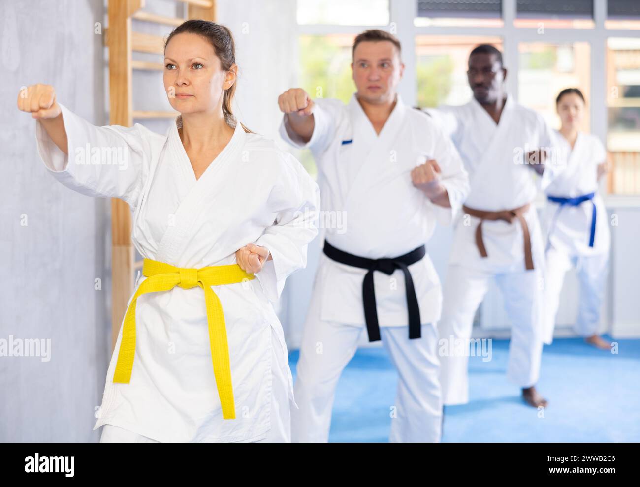 Middle-aged woman attendee of karate classes practicing kata standing ...
