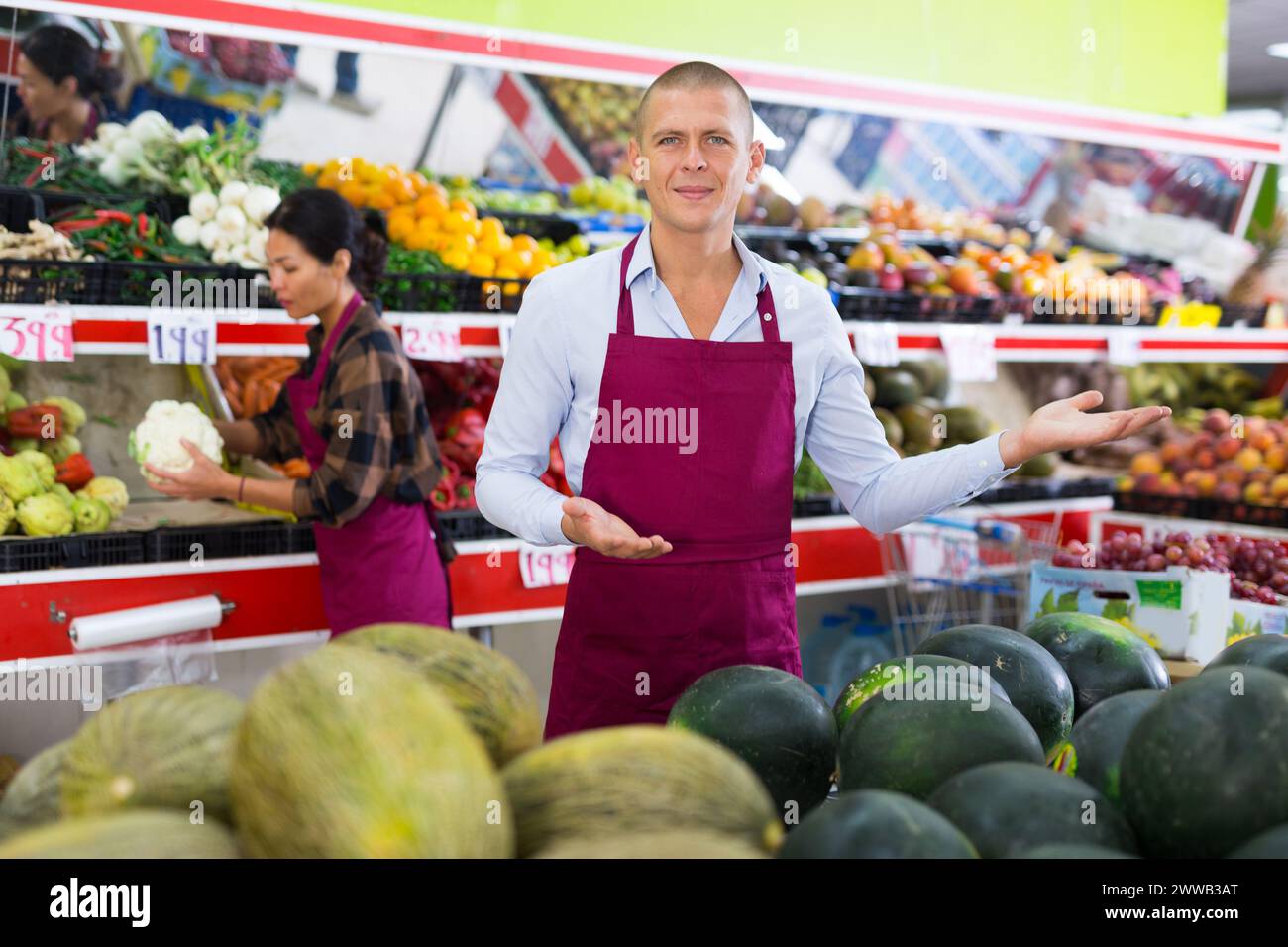 Successful salesman inviting to fruit and vegetable store Stock Photo ...
