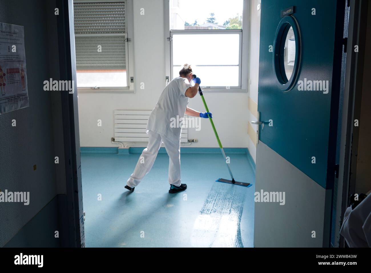 Nursing assistant cleaning a room in the emergency department of a ...