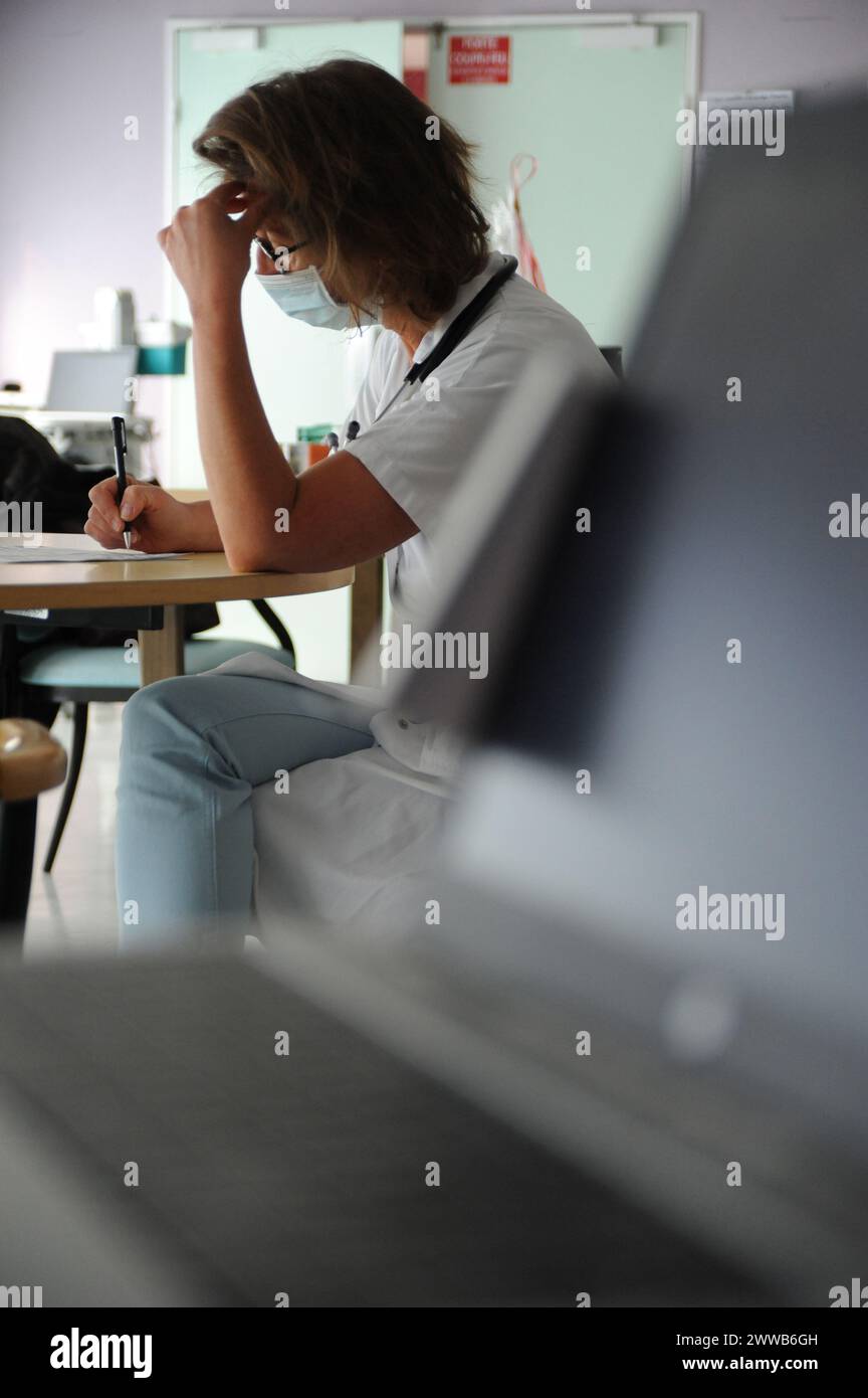 Doctor filling out documents in a hospital Stock Photo - Alamy