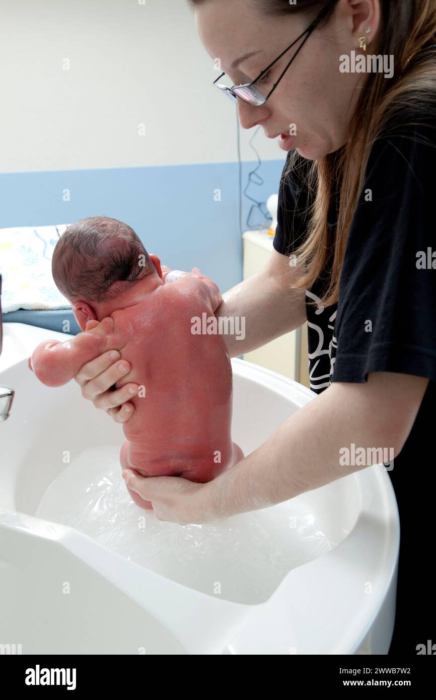 After checking the water temperature, the newborn bathes. Infant toilet ...