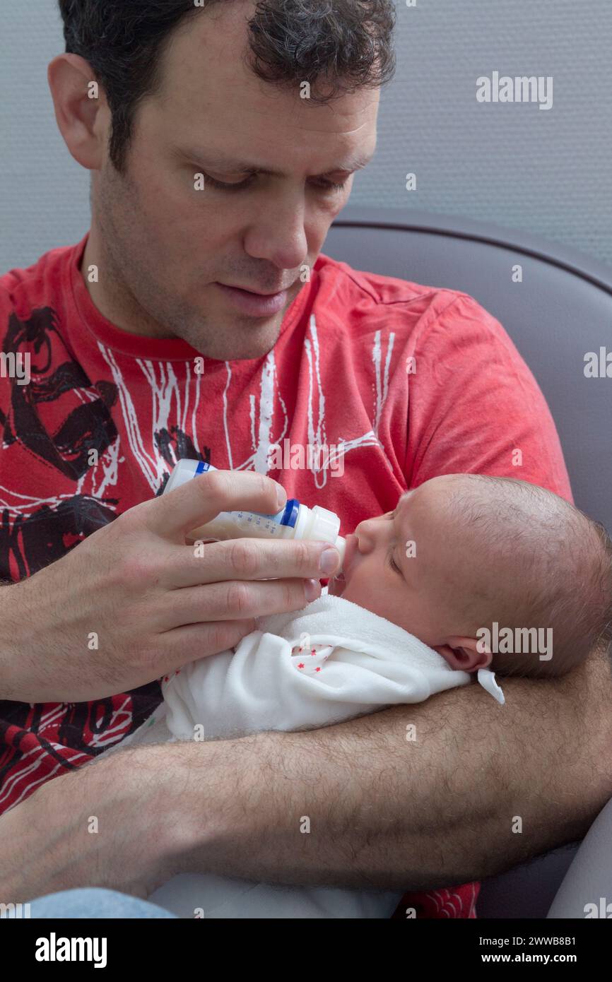Father giving the bottle to his child at the maternity ward Stock Photo ...