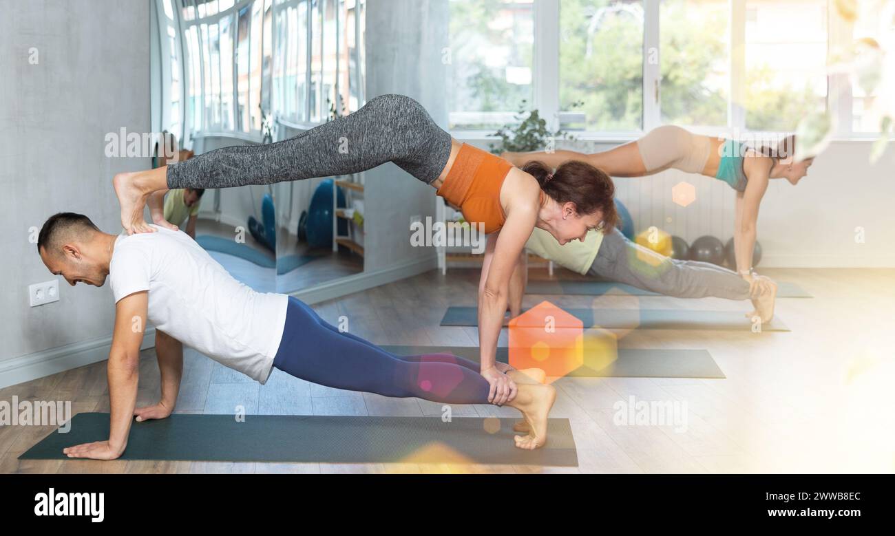 Couples yoga classes in gym. Men and women meditate together in various ...