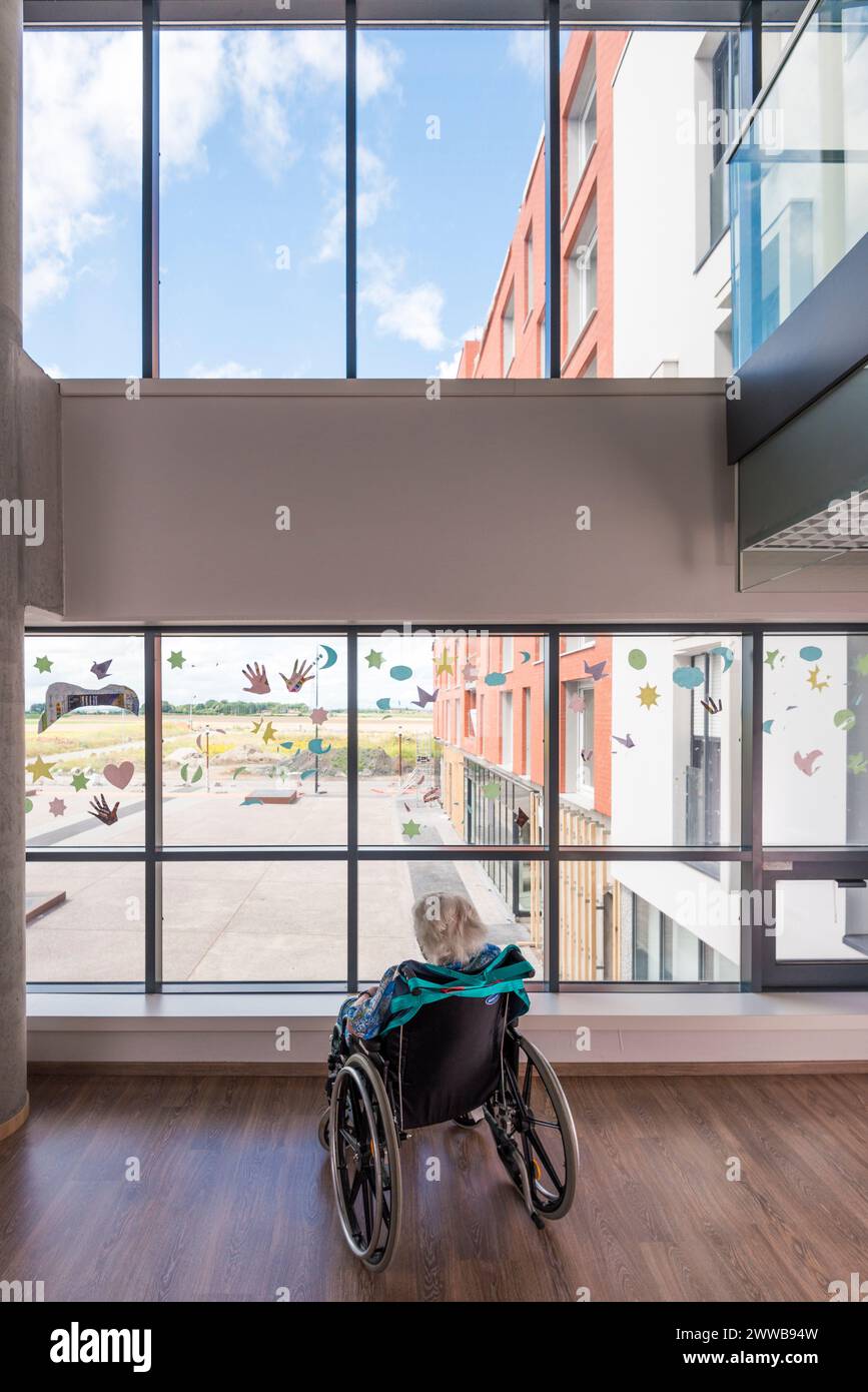 EHPAD - Elderly resident in a wheelchair looking outside through large ...