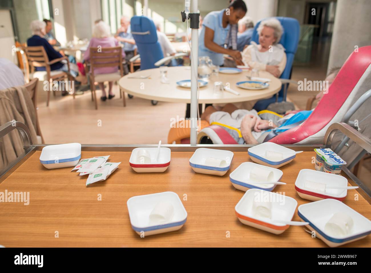 EHPAD - Residents having their meal in the common room. Serving tray ...