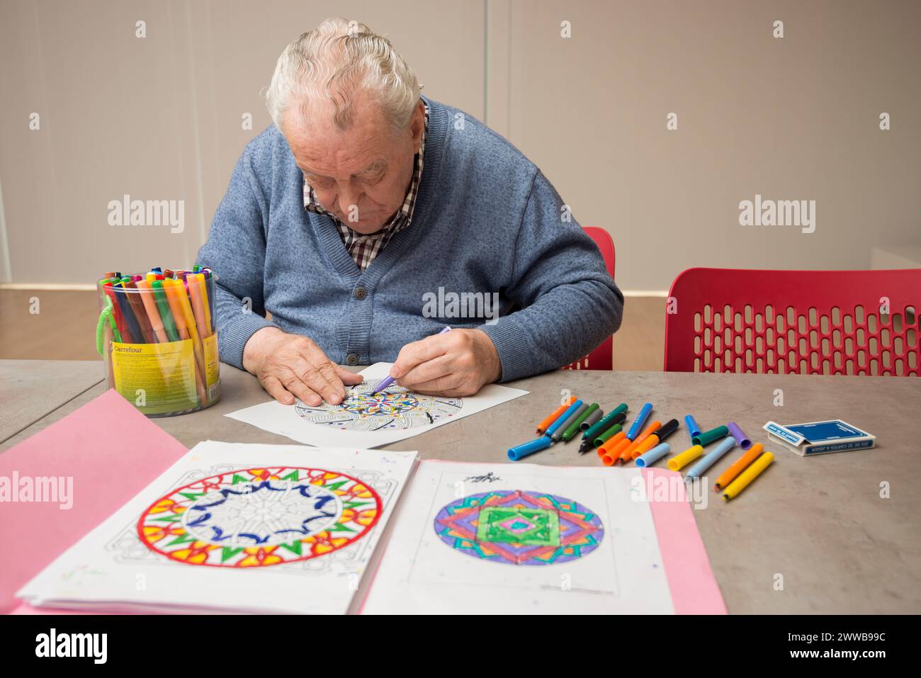 EHPAD - Elderly resident drawing in a common room Stock Photo - Alamy