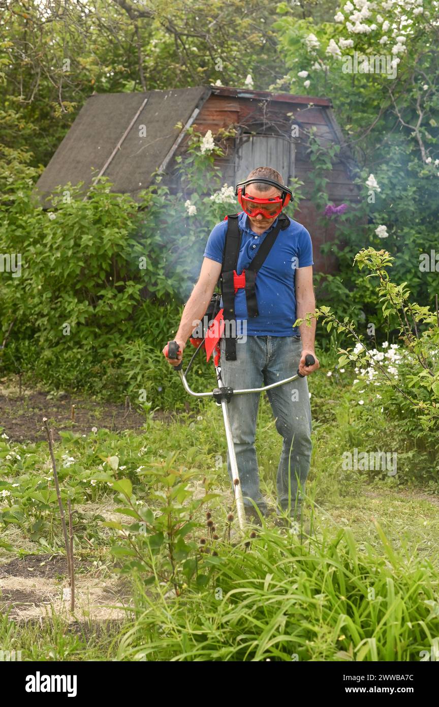 Male mows tall green grass hi-res stock photography and images - Alamy