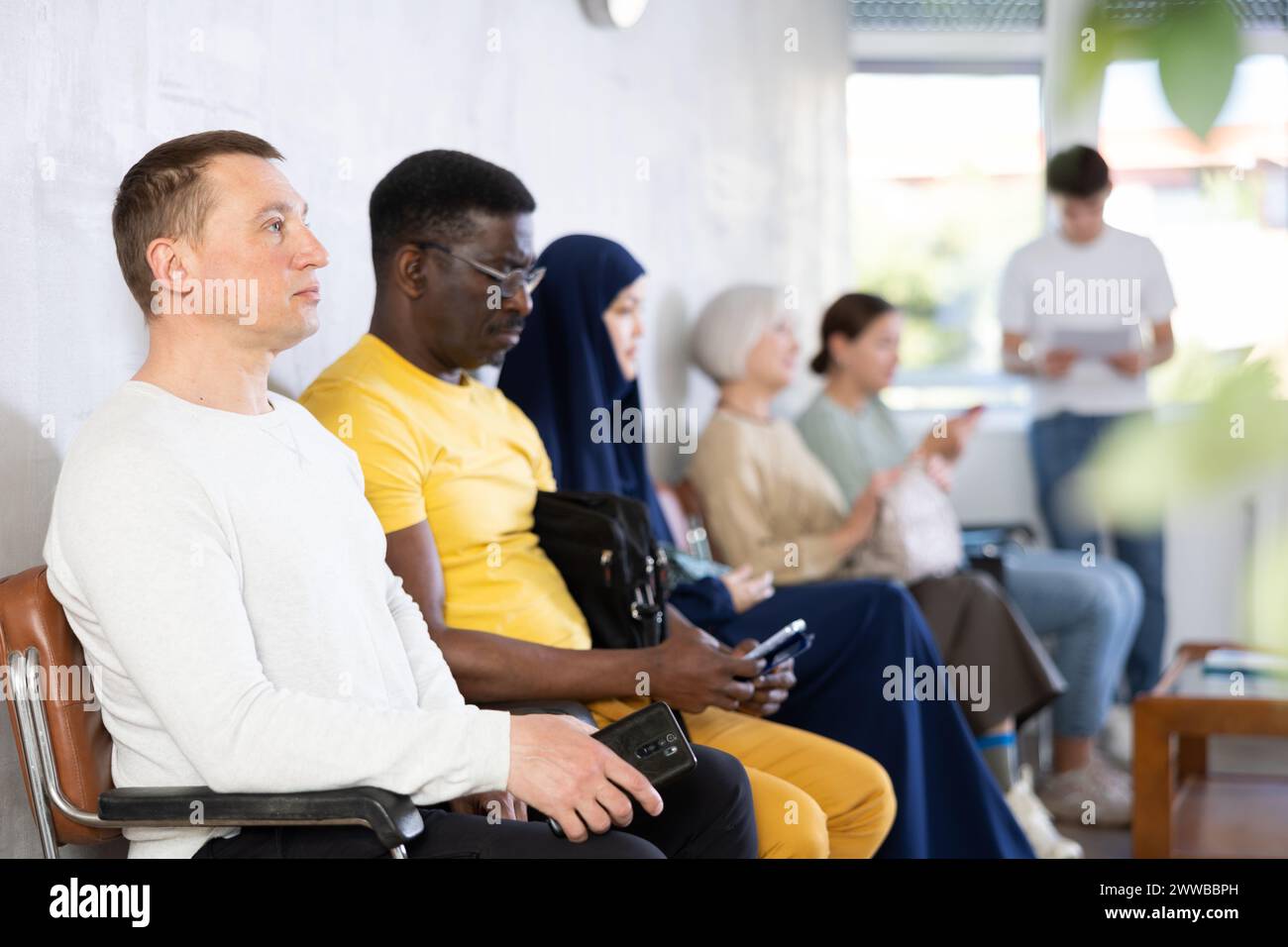 Adult man waiting in line at reception with phone in his hand Stock ...