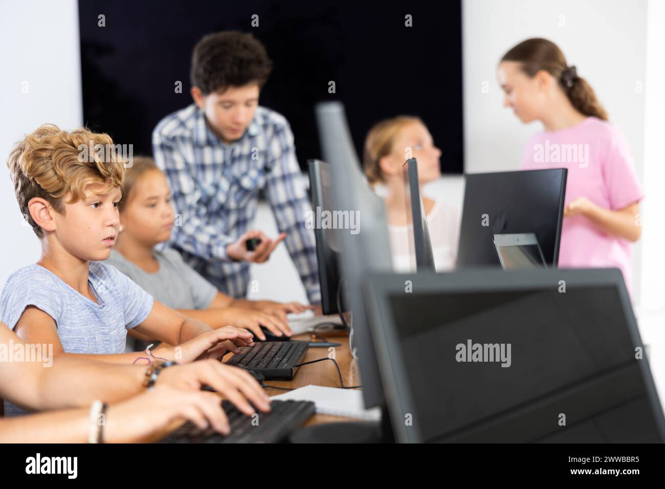 Portrait of male teenage student at computer in school class Stock ...